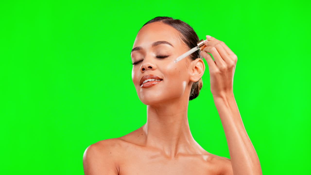 Premium stock video - Green screen, skincare and oil for face of woman