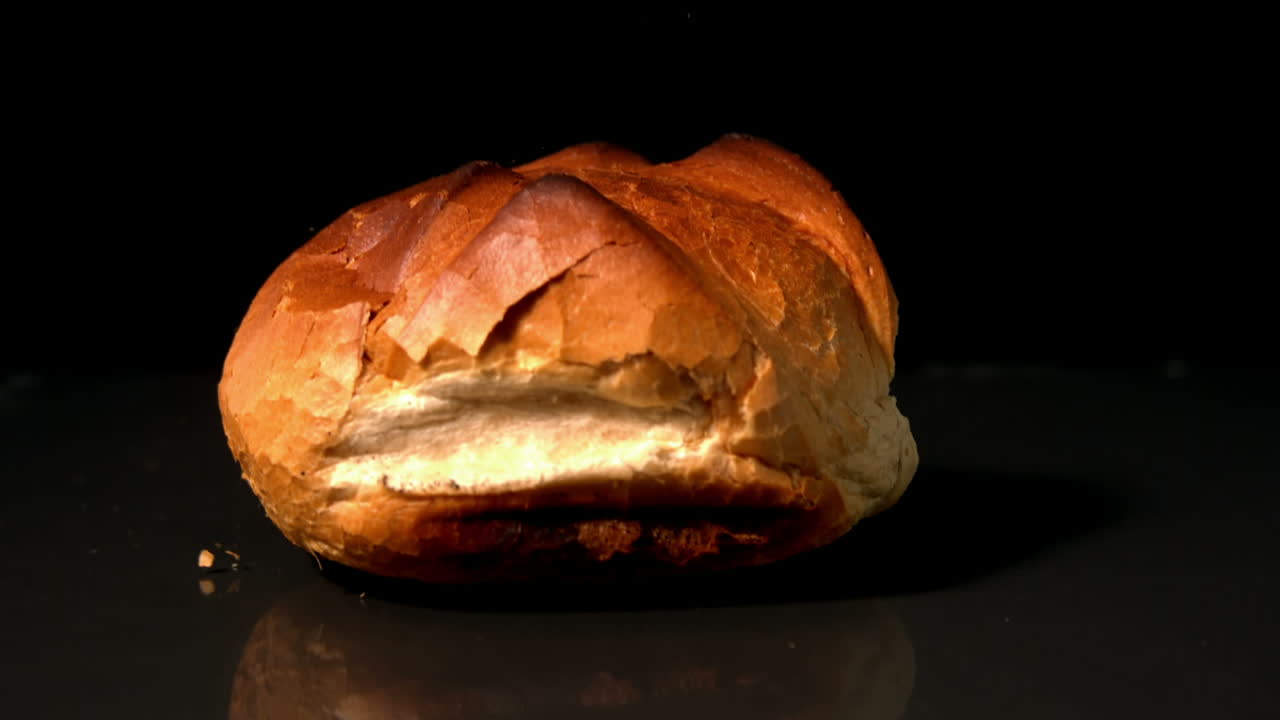 Premium stock video - Loaf of bread falling on black background