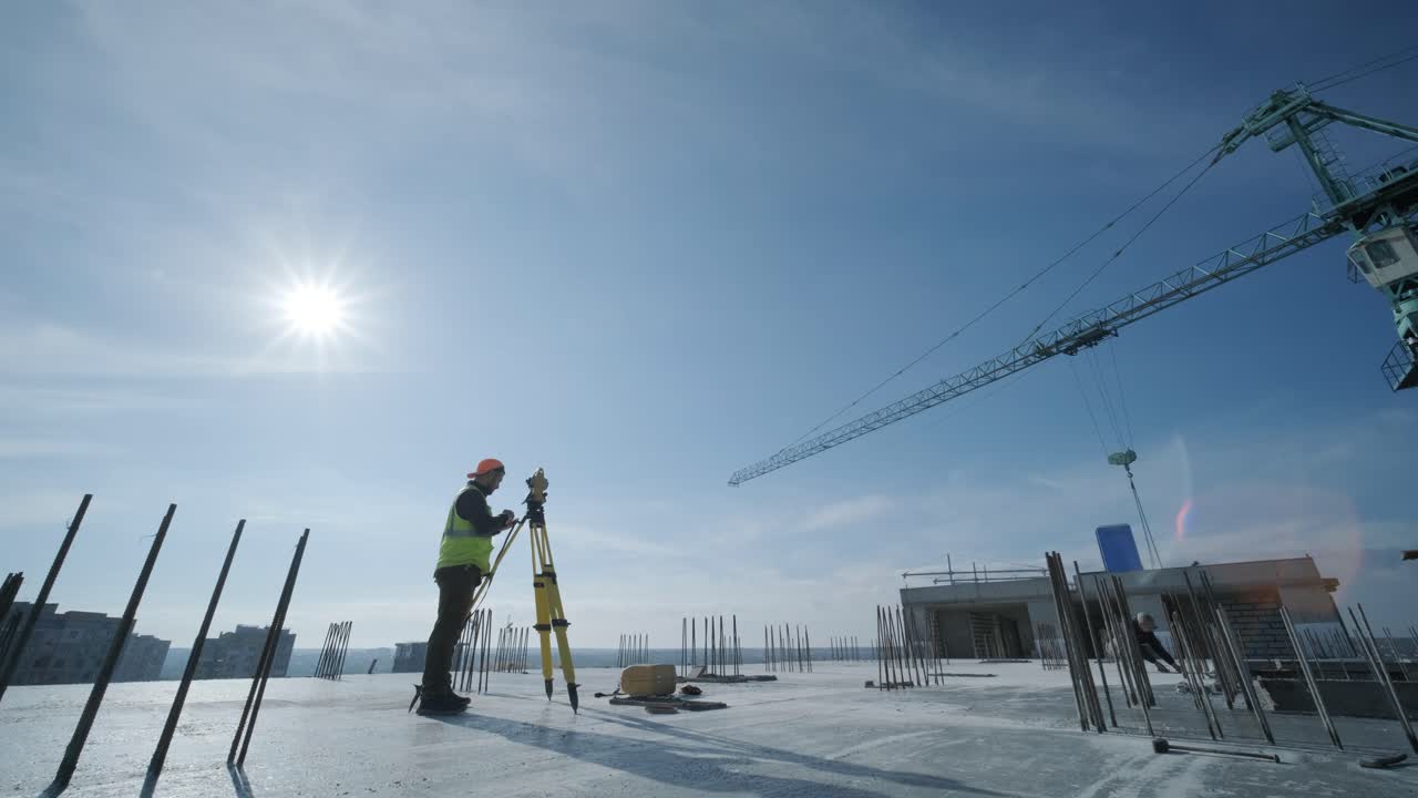 Geodetic works. Surveyor engineer in protective wear and red helmet ...