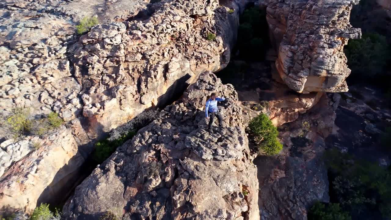 Male rock climber standing over a rocky mountain 4k | Premium Stock ...