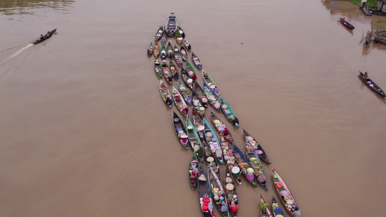 Motorboat pulling along traditional floating market boats Lok baintan ...