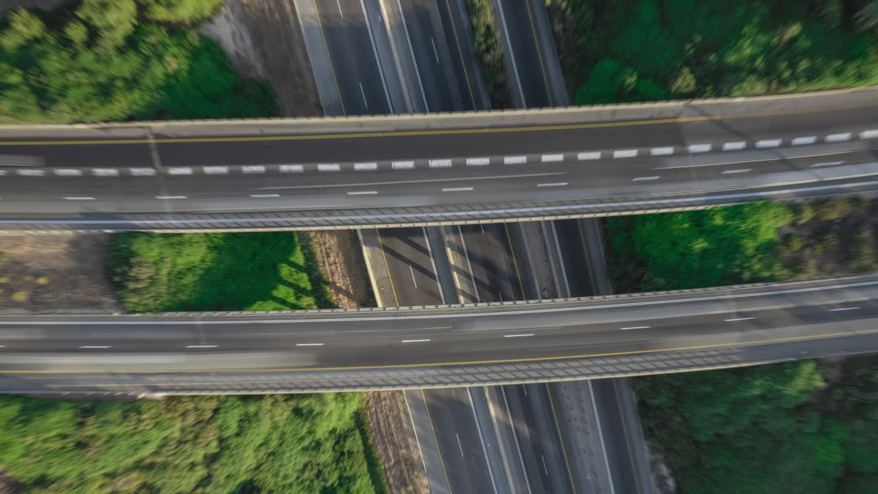 Aerial hyperlapse of a main road junction located in a wild forest ...