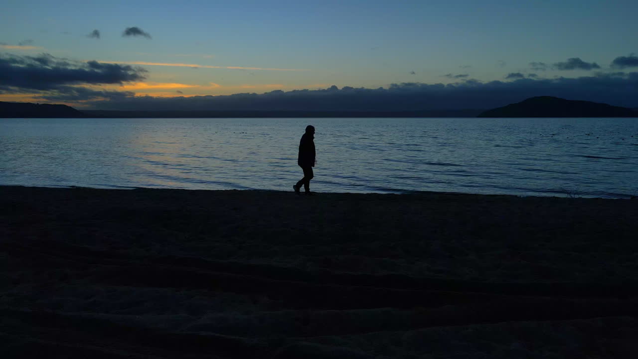 Lonely Person At Dusk Slowly Walking Alone Along Shore At Sunset With ...