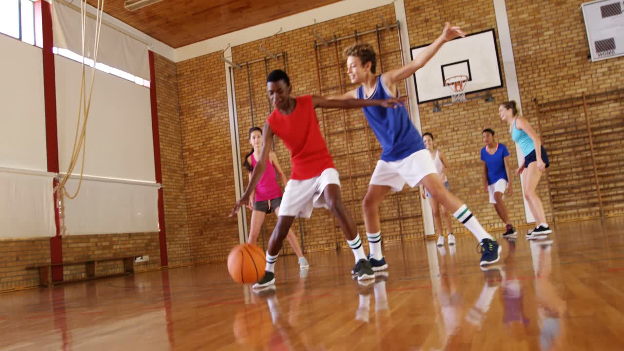 Premium stock video - High school kids playing basketball in the court