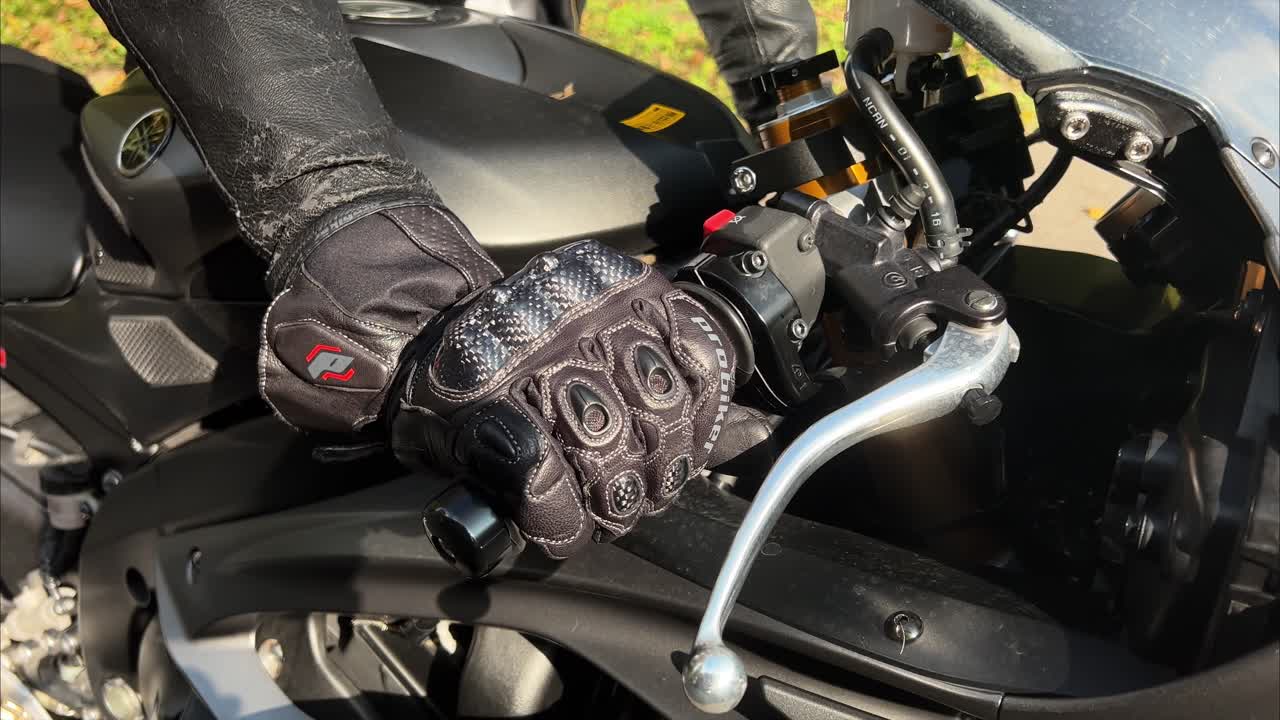 Close up shot of male hand in gloves twisting the throttle grip and ...