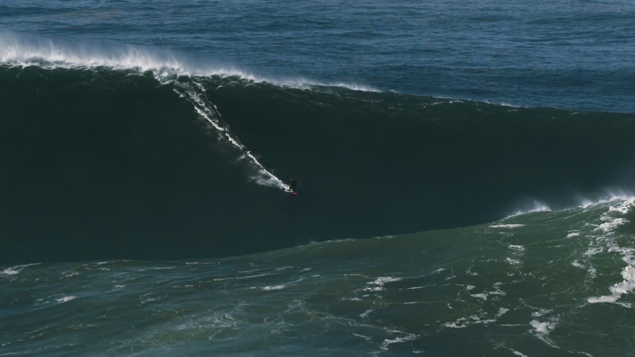 Slow motion of a big wave surfer riding a crazy monster wave in nazaré ...