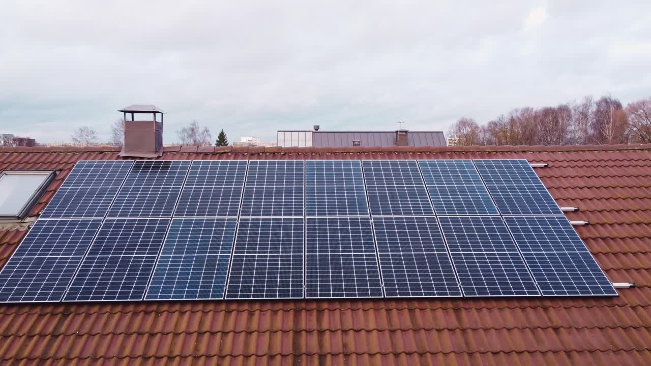 Aerial dolly in towards set of solar panels installed on the roof of ...
