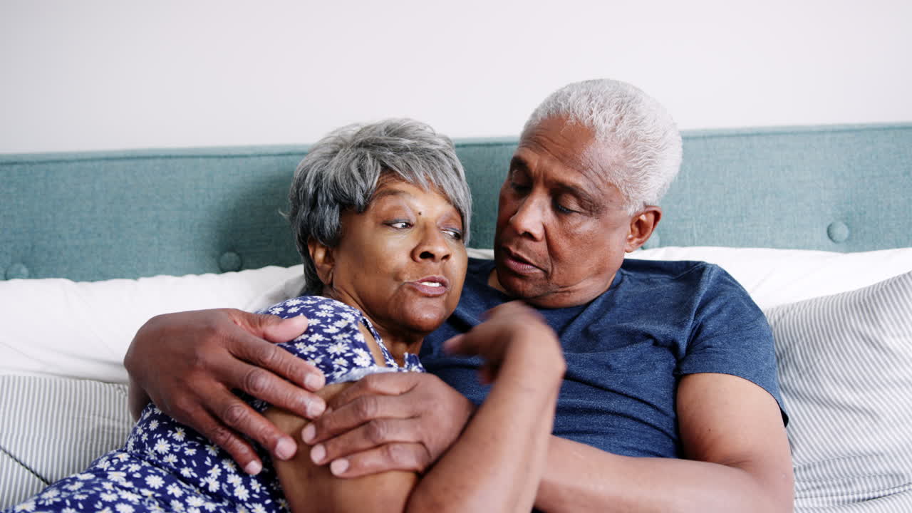 Loving senior couple cuddling in bed in morning Premium Stock Video Footage