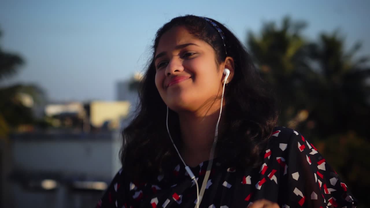 Premium stock video - A girl hearing music with her headphone on