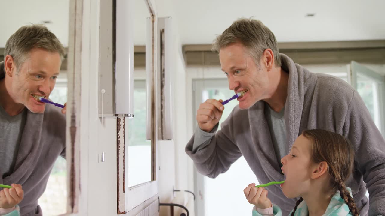 Premium stock video - Father and daughter brushing off their teeth 4k