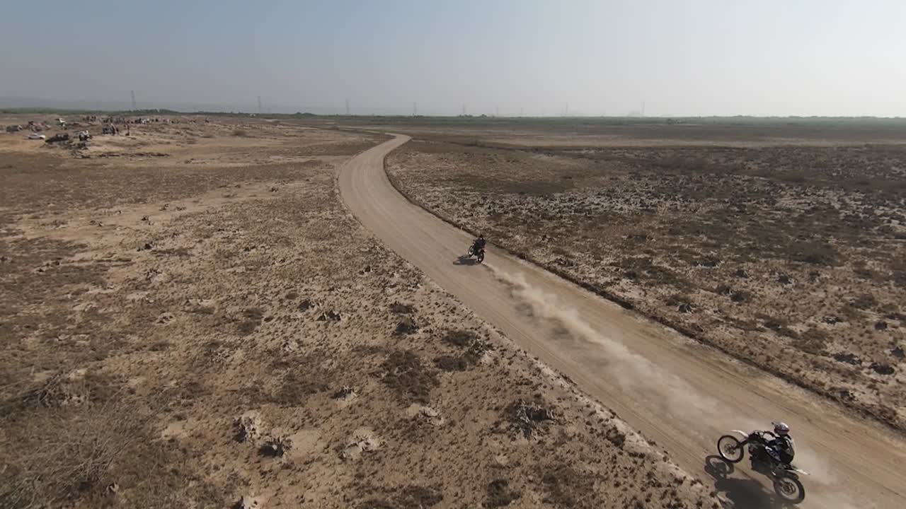 Drone Shot Following Two Motorcycles Racing Down A Desert Highway Free ...