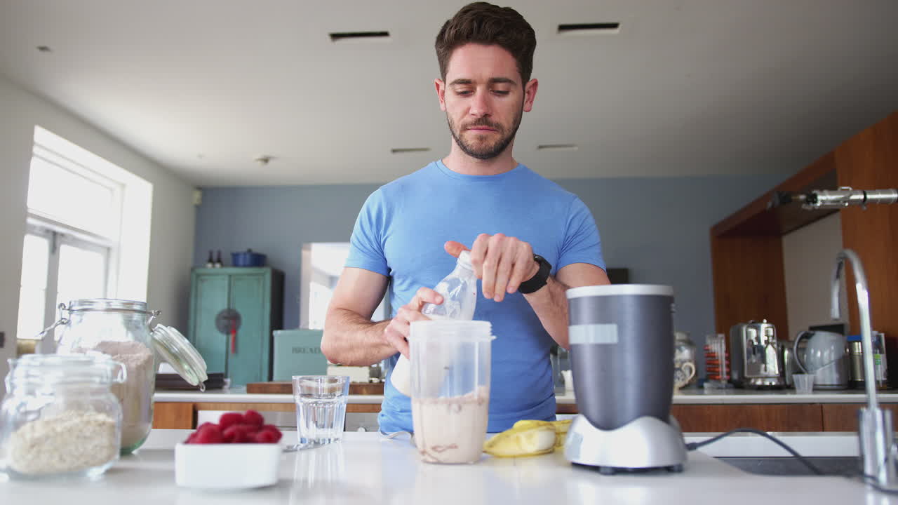 Premium stock video - Man making protein shake after exercise at home