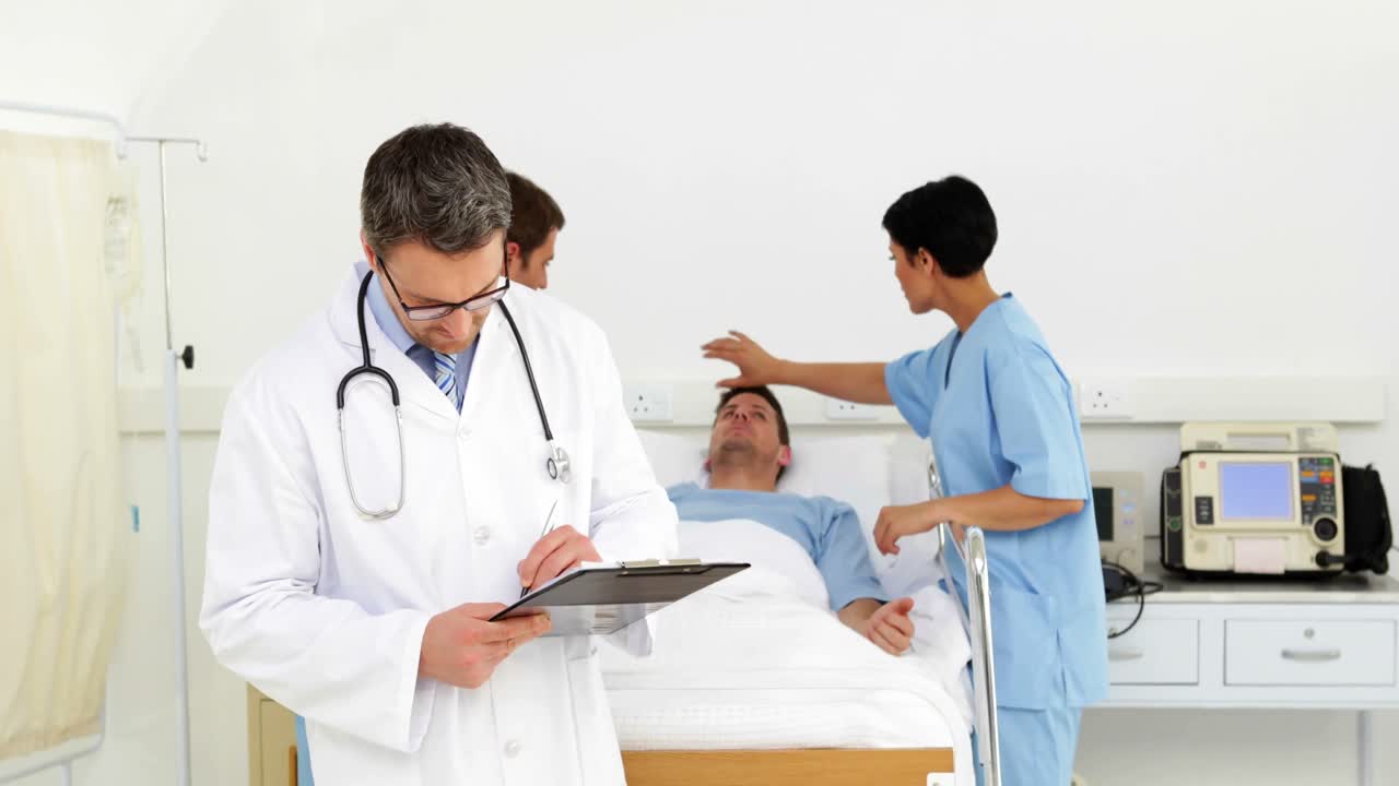 Premium stock video - Doctors and nurse watching over sick patient