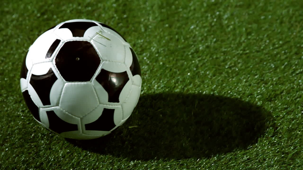 Football spinning around on grass Premium Stock Video Footage