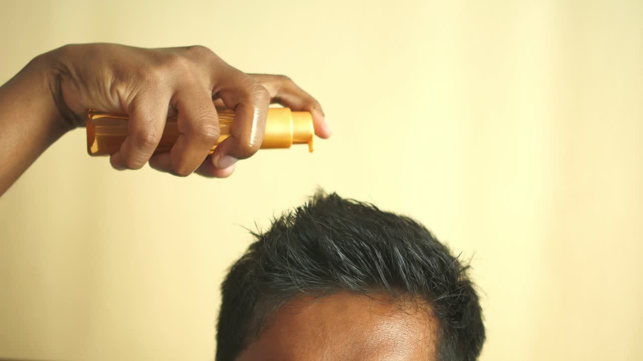 Man applying hair oil to his hair Premium Stock Video Footage