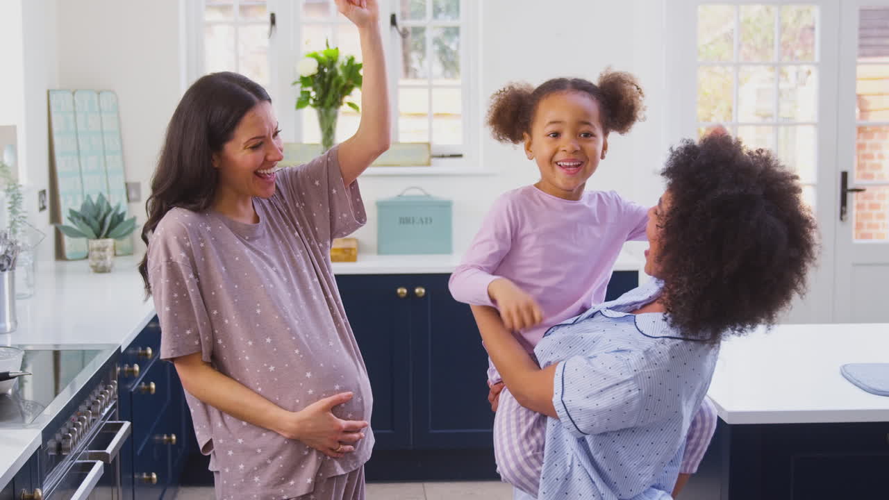 Pregnant Family With Two Mums Dancing Making Morning Pancakes In ...
