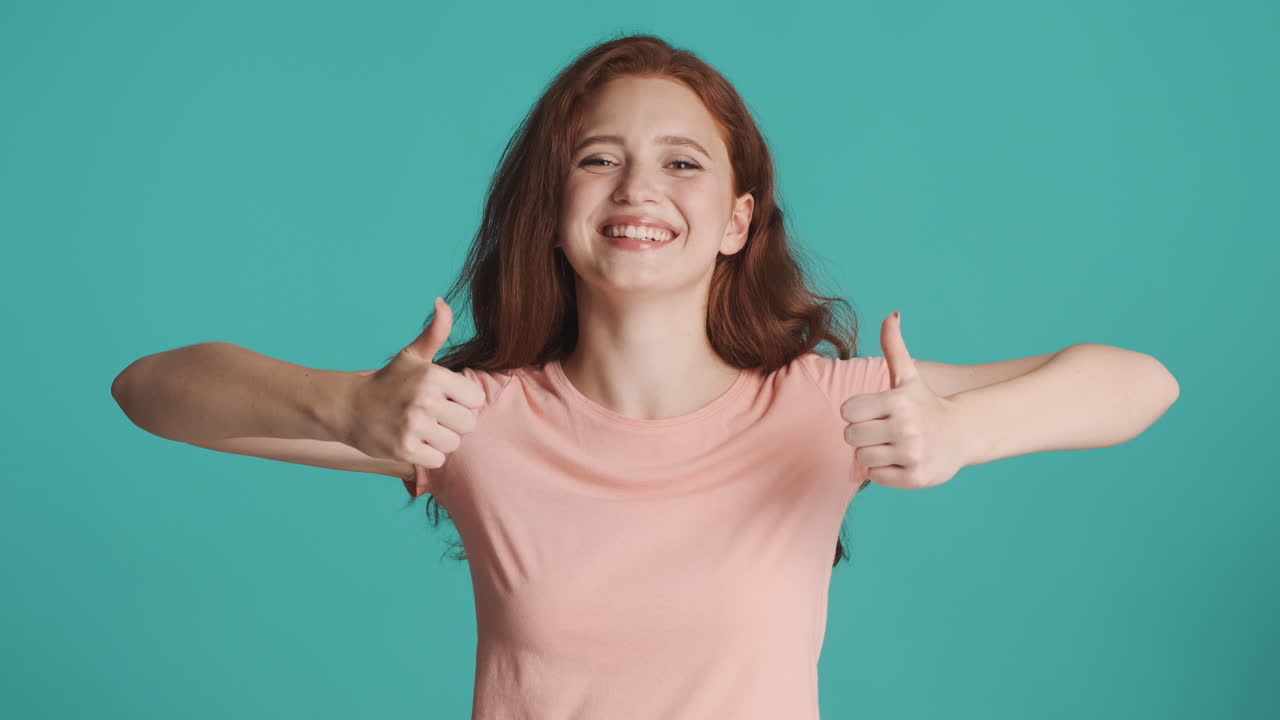 무료 스톡 영상 - 은 머리의 소녀가 르키즈색 배경에서 카메라를 보고 있습니다.