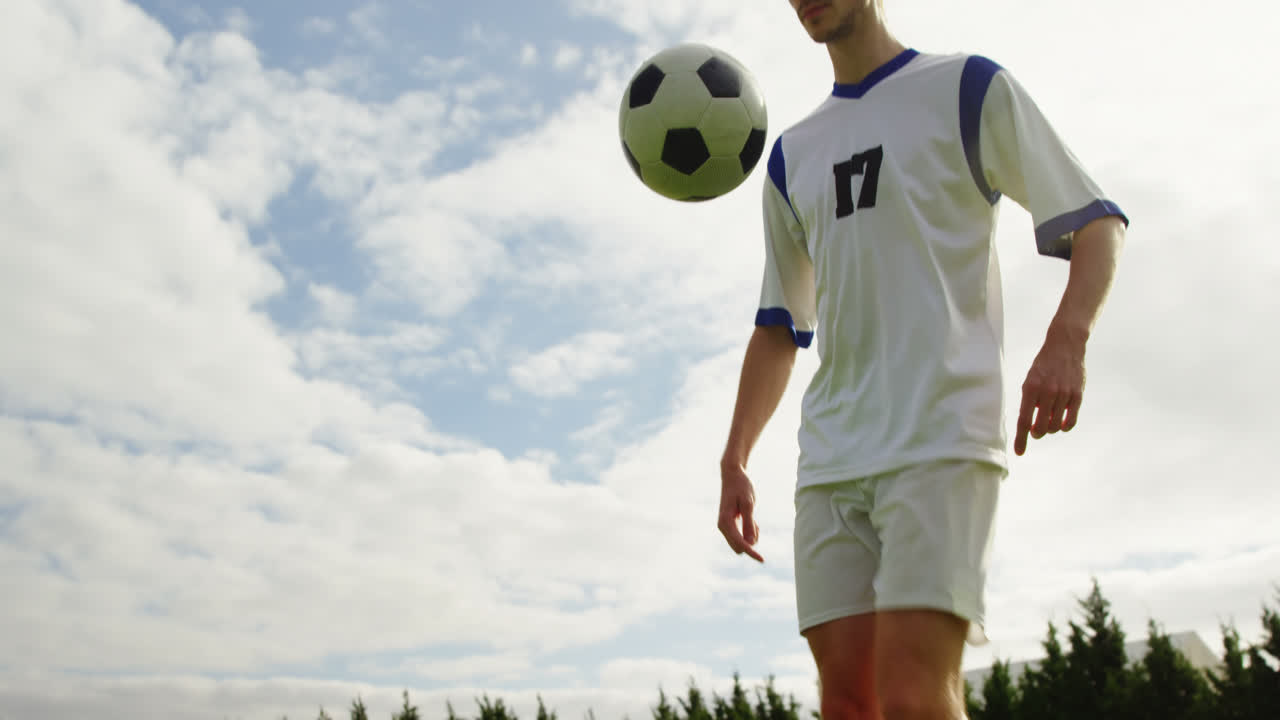 Football player juggling a ball | Premium Stock Video Footage