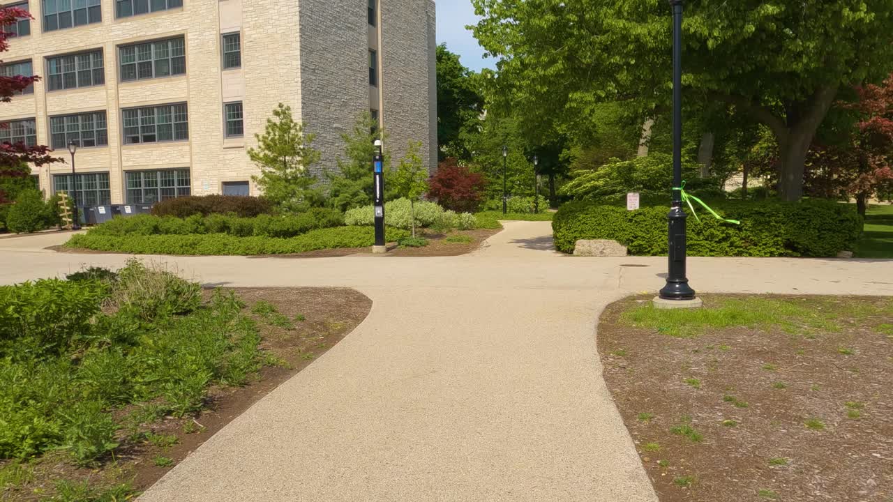 Student Walking On University College Campus With Beautiful Landscaping ...