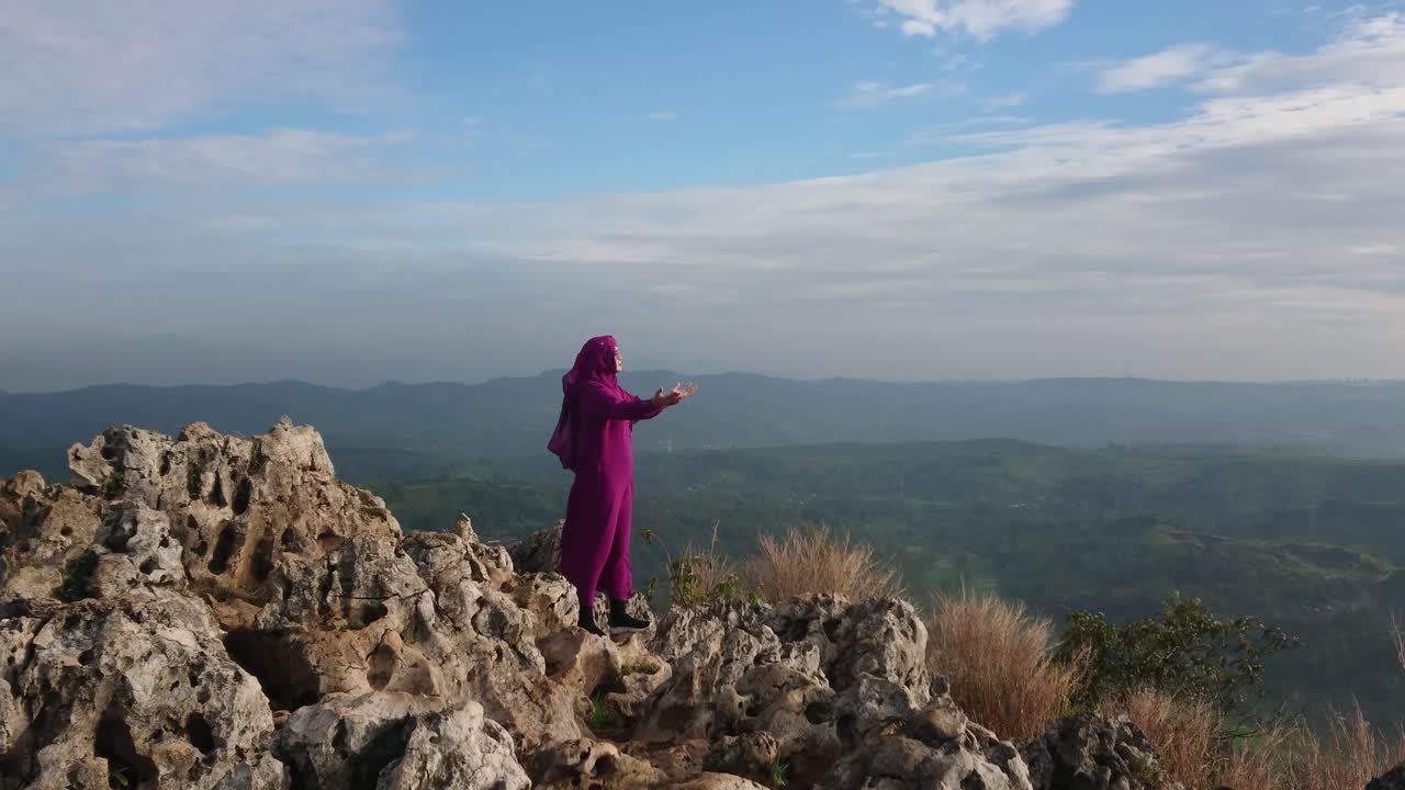 Islamic Woman In Purple Burqa Holding Hands Out In Prayer To God On ...