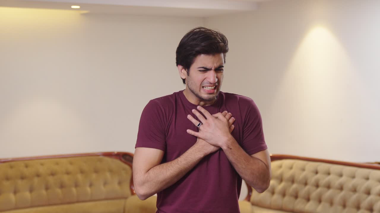 Premium stock video - Young indian man having a heart attack