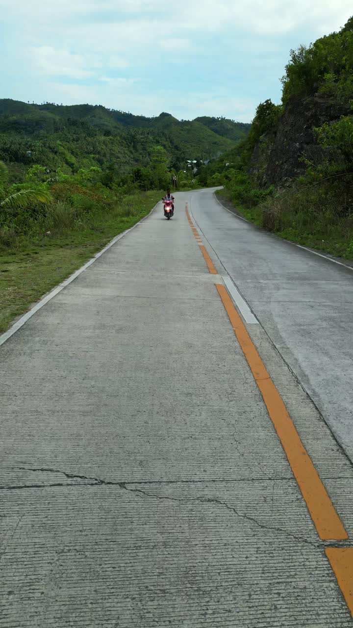 Premium stock video - Vertical, front view of a tourist riding scooter ...