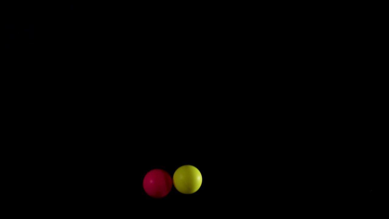 Red and yellow balls bouncing in darkness | Premium Stock Video Footage