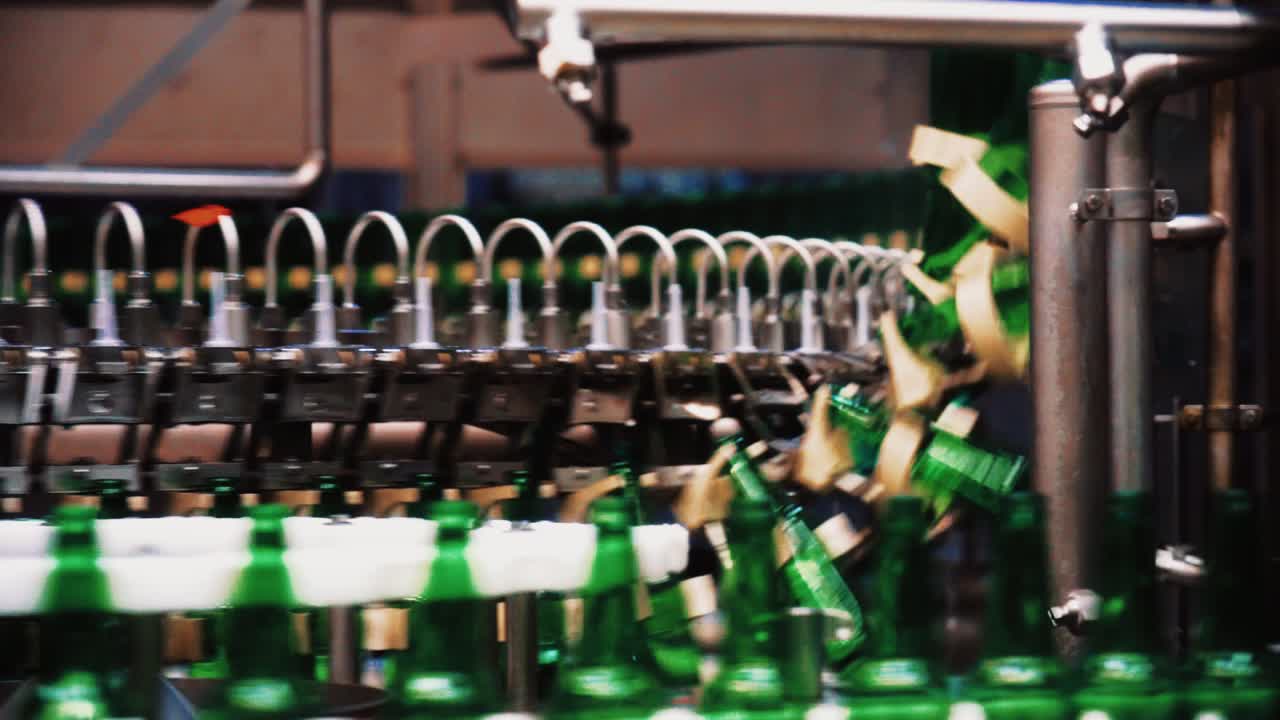 Close-up shot inside bottling line factory of glass beer bottles ...