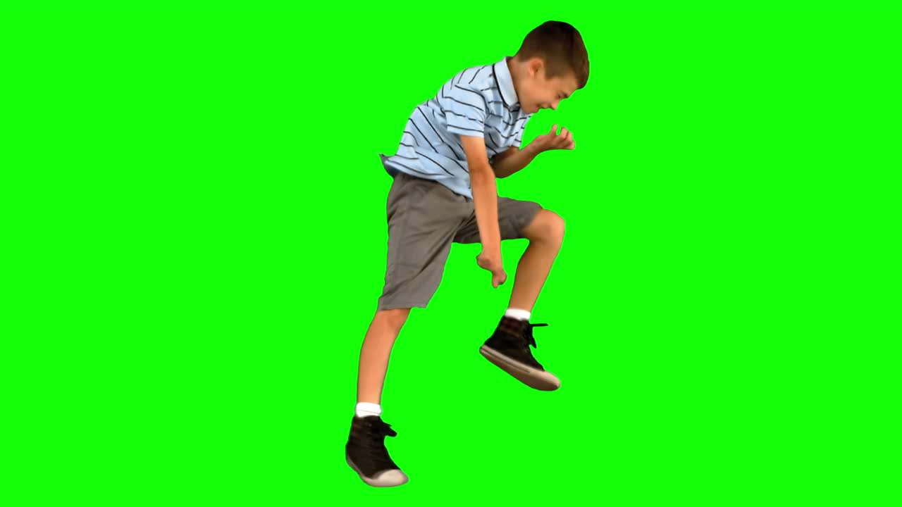 Premium stock video - Little boy jumping on green screen