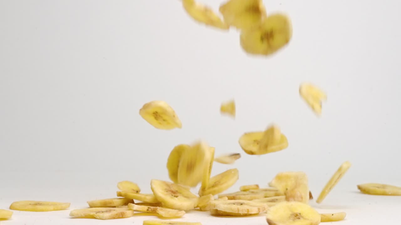 Premium stock video - Crispy yellow freeze dried banana chips falling ...
