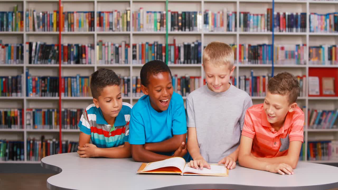 Premium stock video - School kids reading book together in library