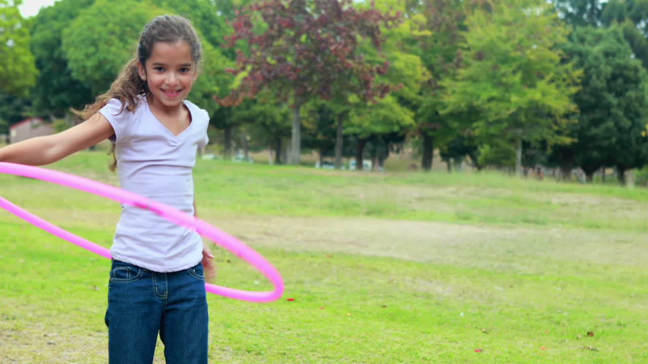 Premium stock video - Little girl doing hula hoop