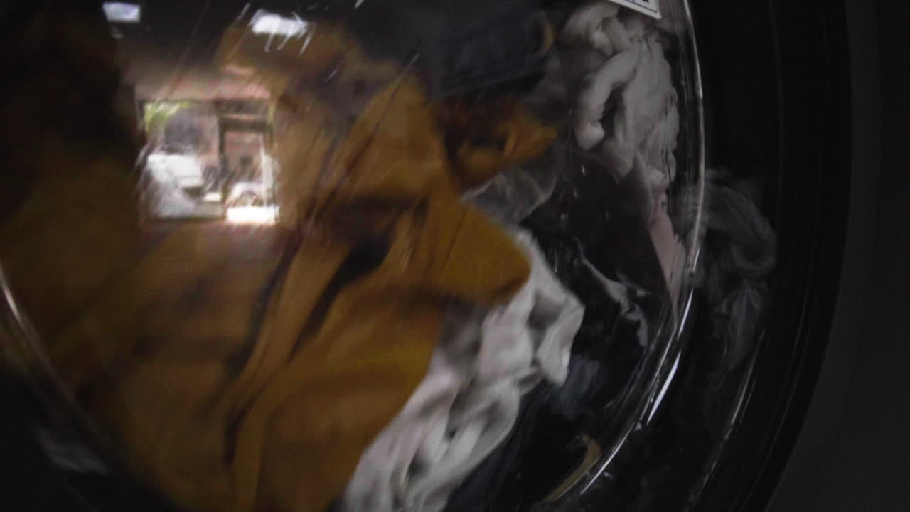Clothes Spinning Inside A Front Load Washing Machine In A Laundry Shop ...