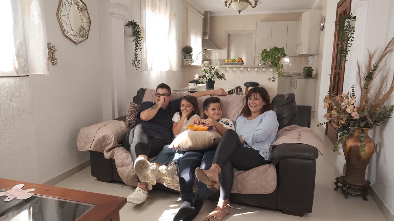 Non-normative family watching television together at home | Premium ...