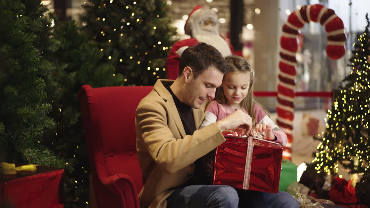 Father and daughter opening a Christmas gift | Premium Stock Video Footage