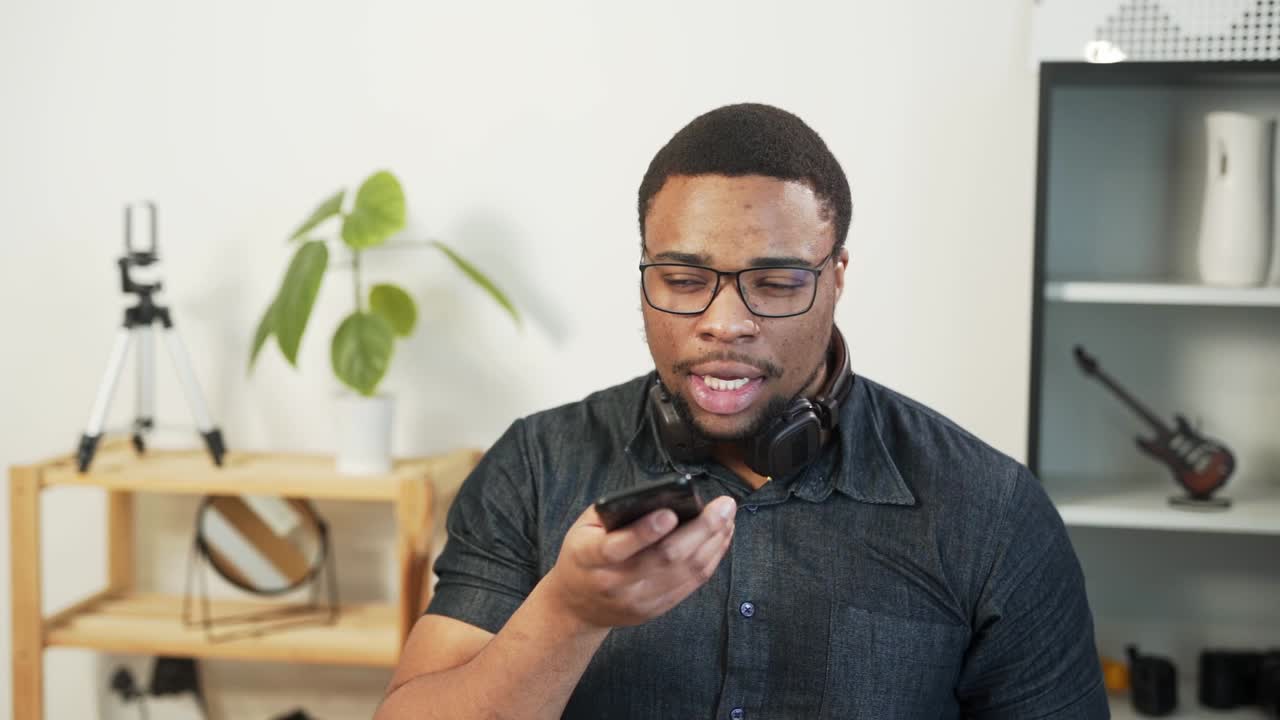 Charismatic black man records a voice message on a smartphone | Premium ...