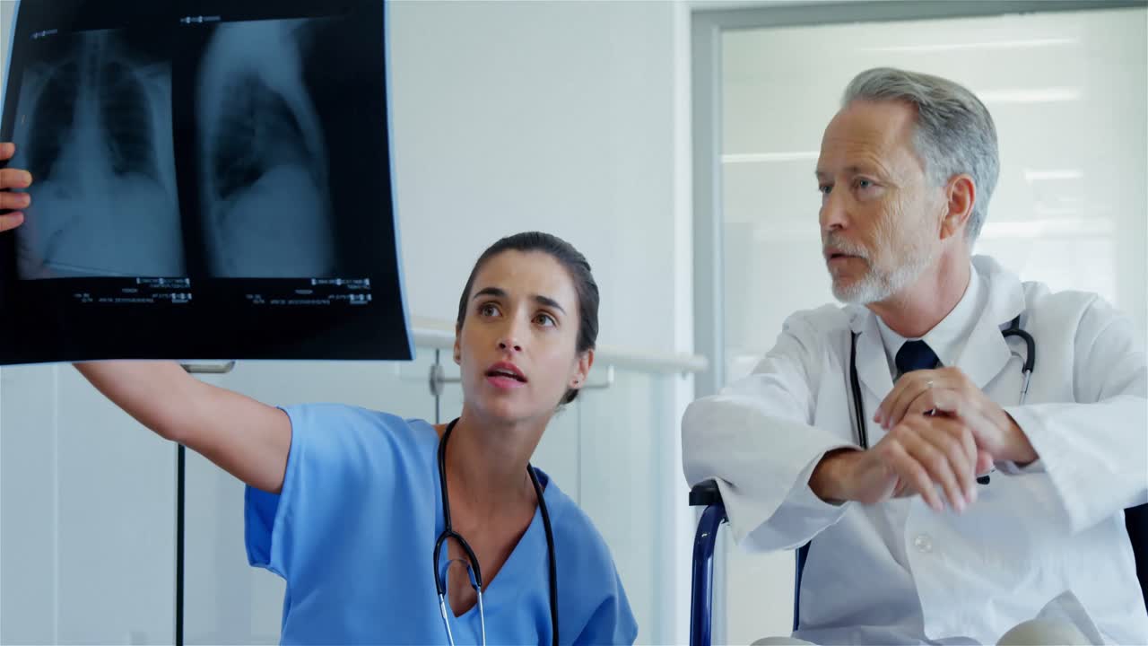 Surgeon and colleague discussing over an x-ray Premium Stock Video Footage