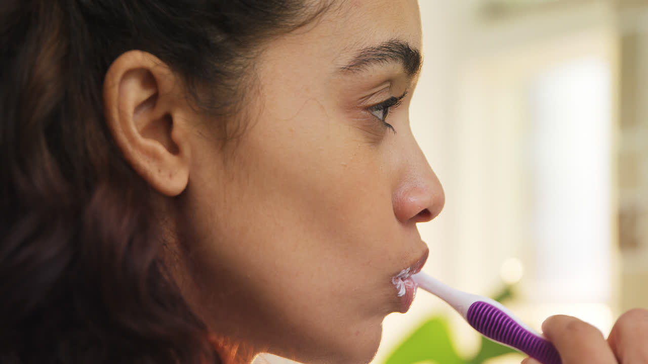 Young woman brushing her teeth with tooth brush 4k 4k Premium Stock ...