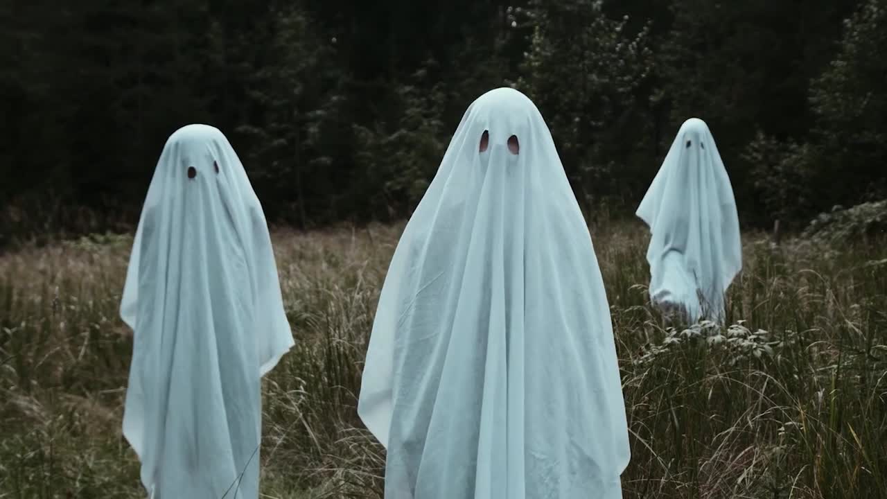 Three kids dressed up as ghosts celebrating halloween white ghost in ...