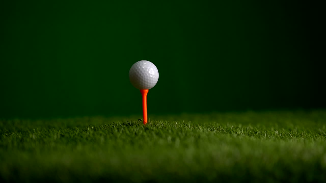 Golf ball on tee Slow motion slide in golf course on green background ...