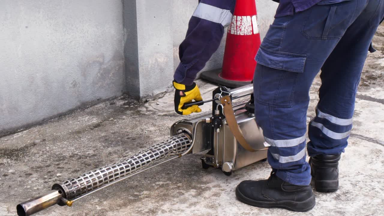 Slow motion of worker starting fogging service with insecticides ...