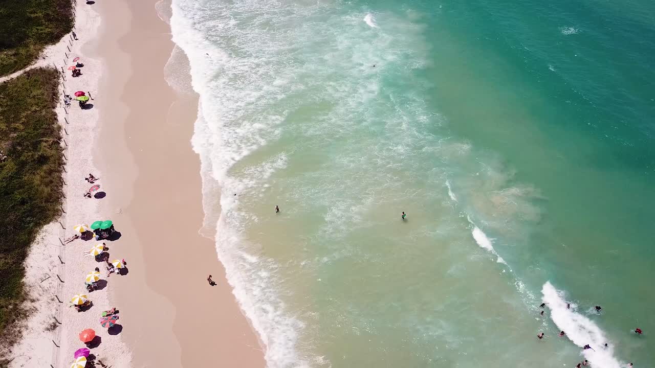 Premium stock video - Drone shoot of tourists bathing on a brazilian beach