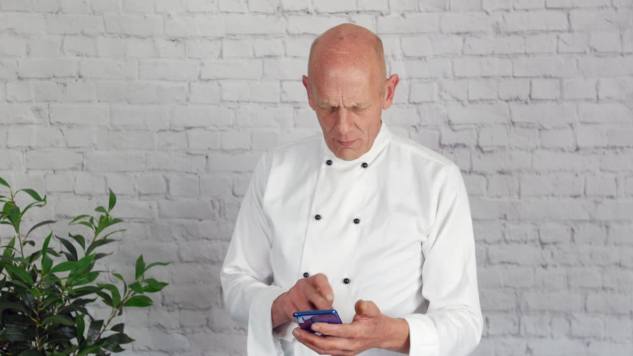 Premium stock video - A male head chef is raking a break from the ...