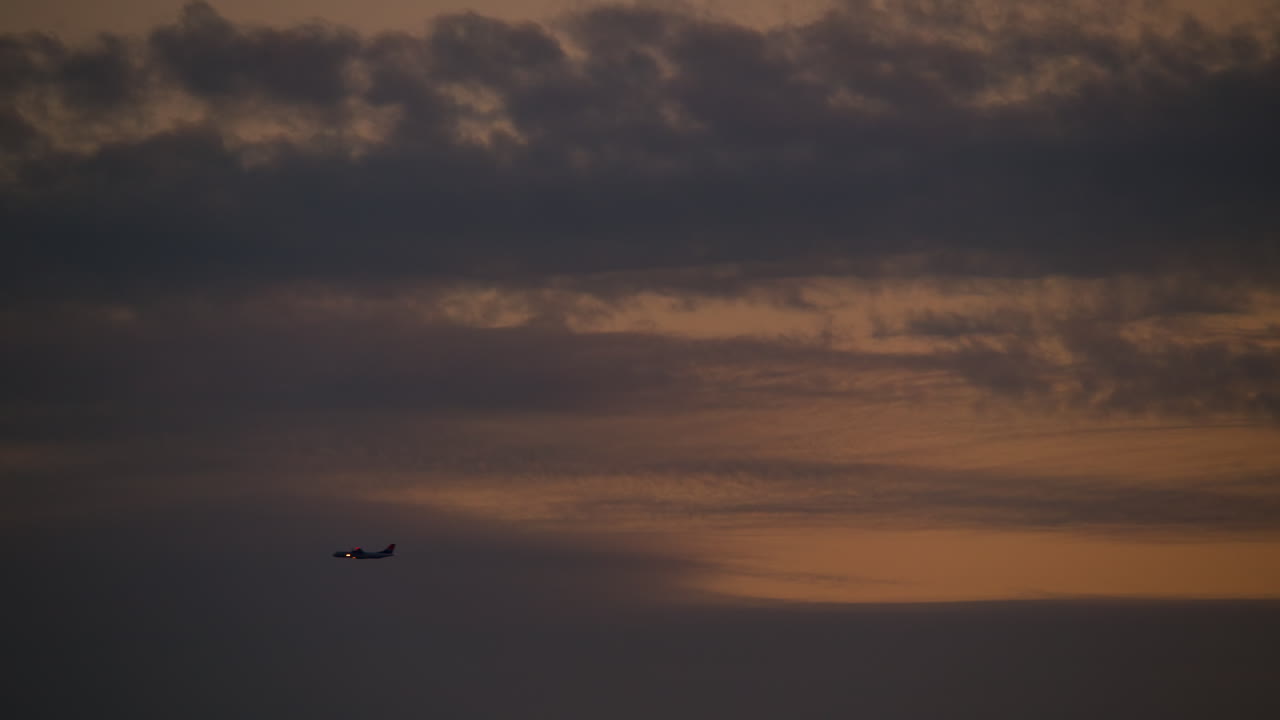 Airplane flying in a sunset sky Premium Stock Video Footage