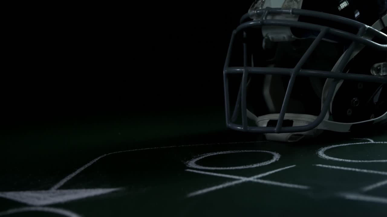 American football head gear on green board with strategy drawing 4k ...