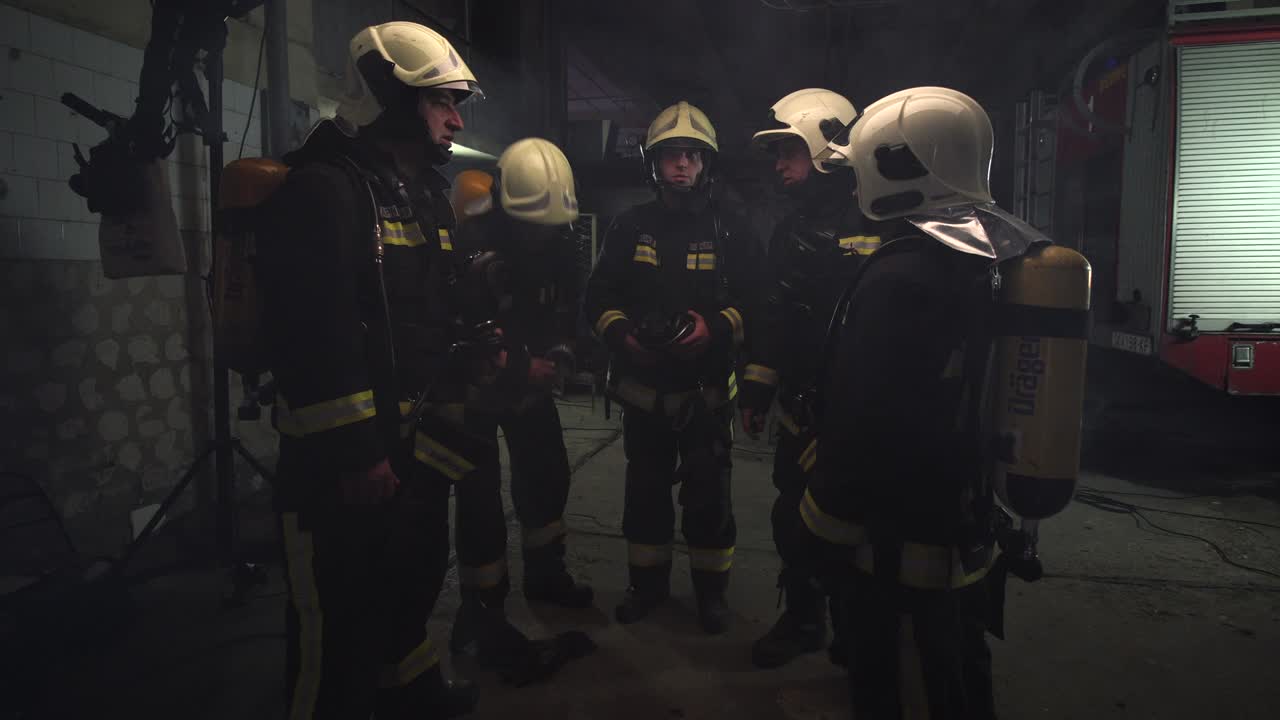 Group of five firefighters wearing full equipment in smokey area ...