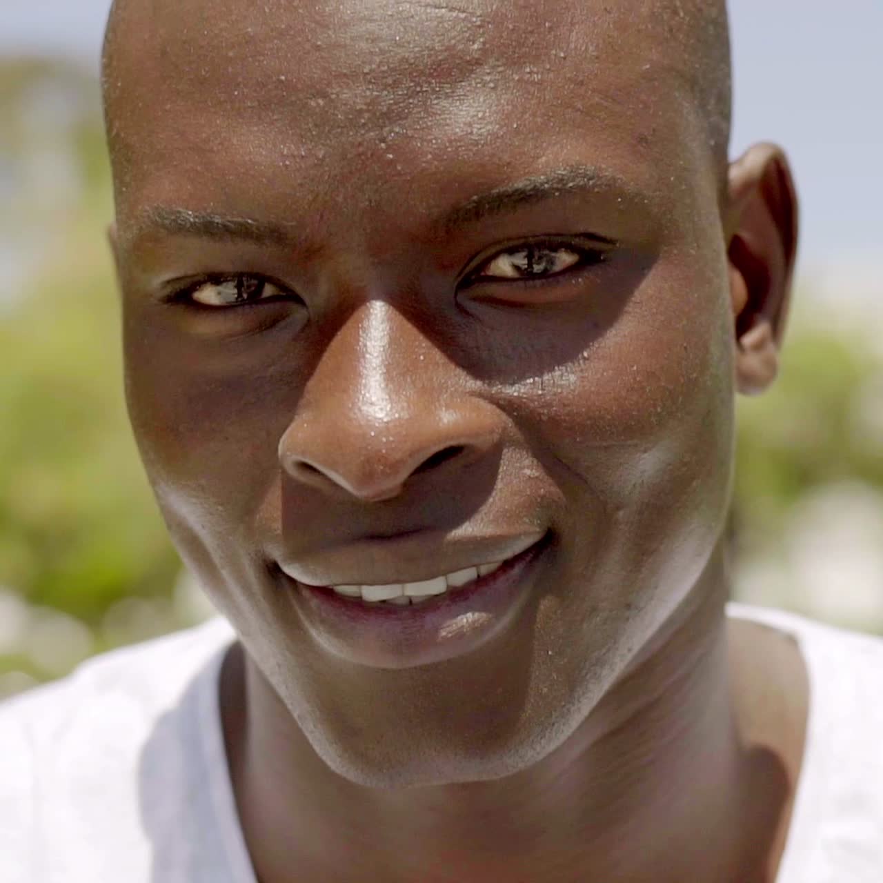 Vídeo de arquivo Premium - Close-up de homem negro careca bonito sorridente