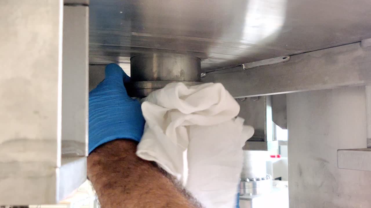 Premium stock video - A mechanic worker hand cleaning pipe flange pump ...
