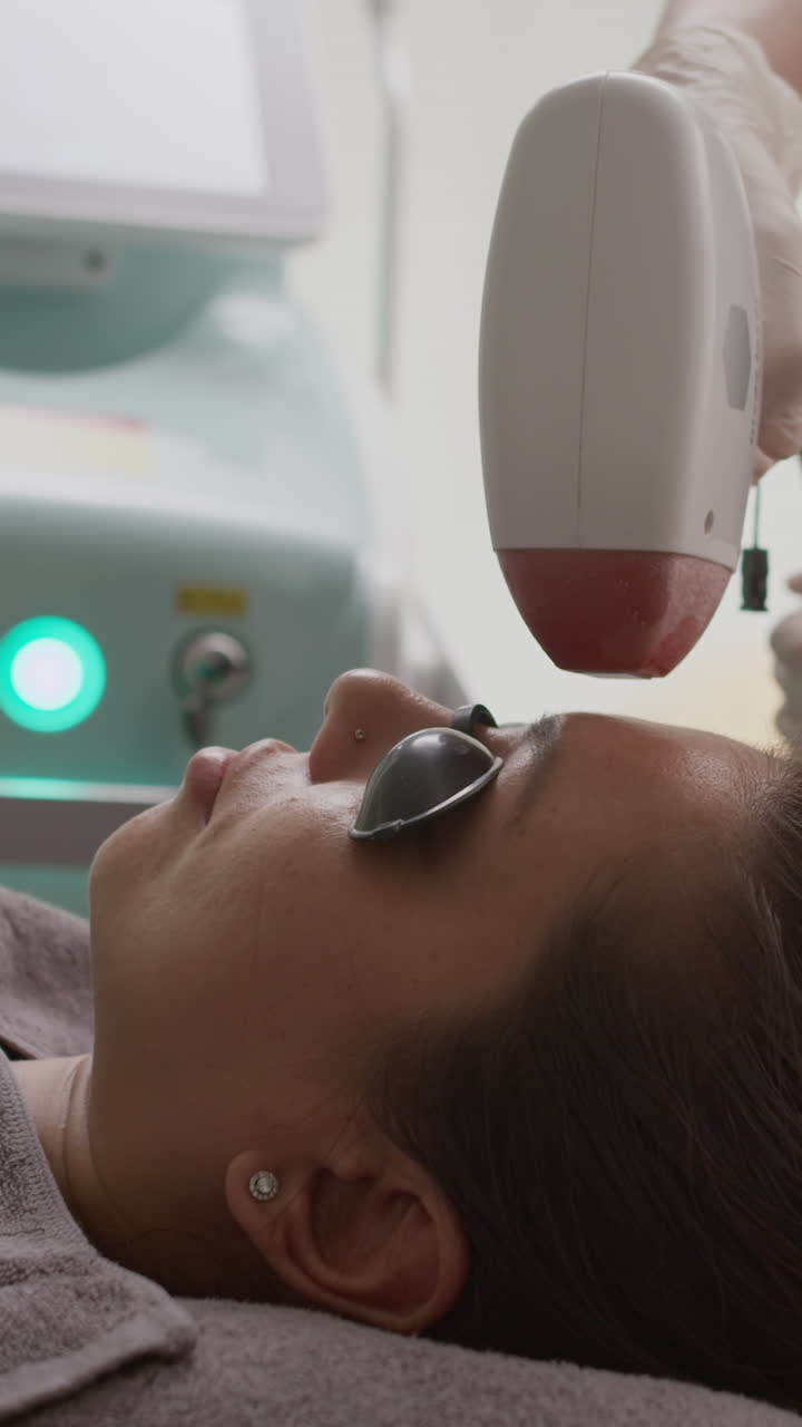 Esthetician Using Laser Machine during Procedure on Face of Female ...