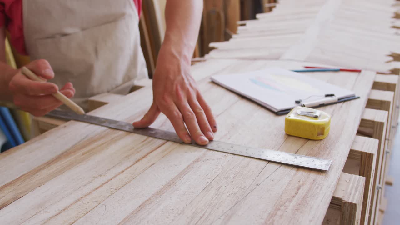 Caucasian male surfboard maker working in his studio and making a ...